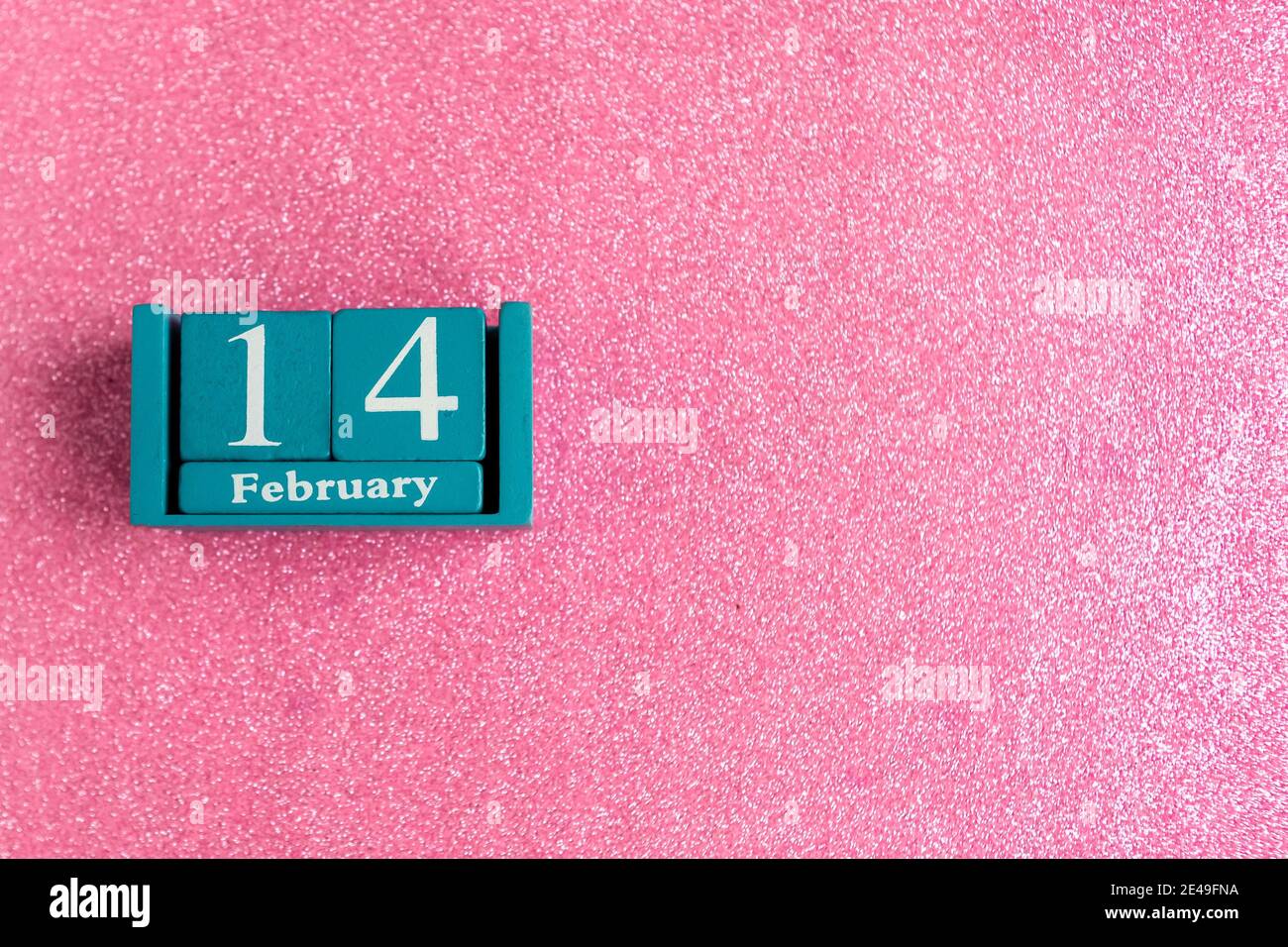 February 14. Blue cube calendar with month and date on pink glitter ...