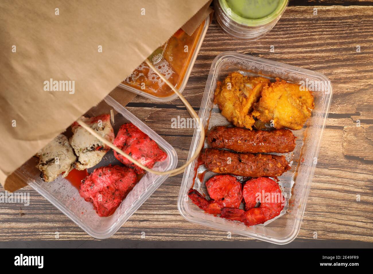 Top view of traditional Indian food in a plastic box on a wooden table ...
