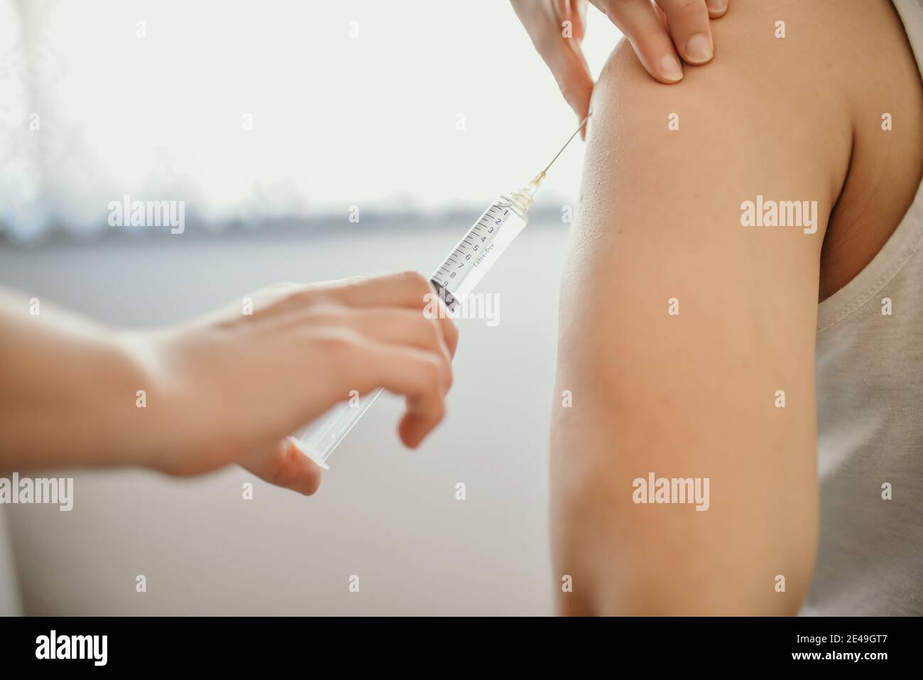 Selective focus shot of a person injecting medicine in the shoulder ...