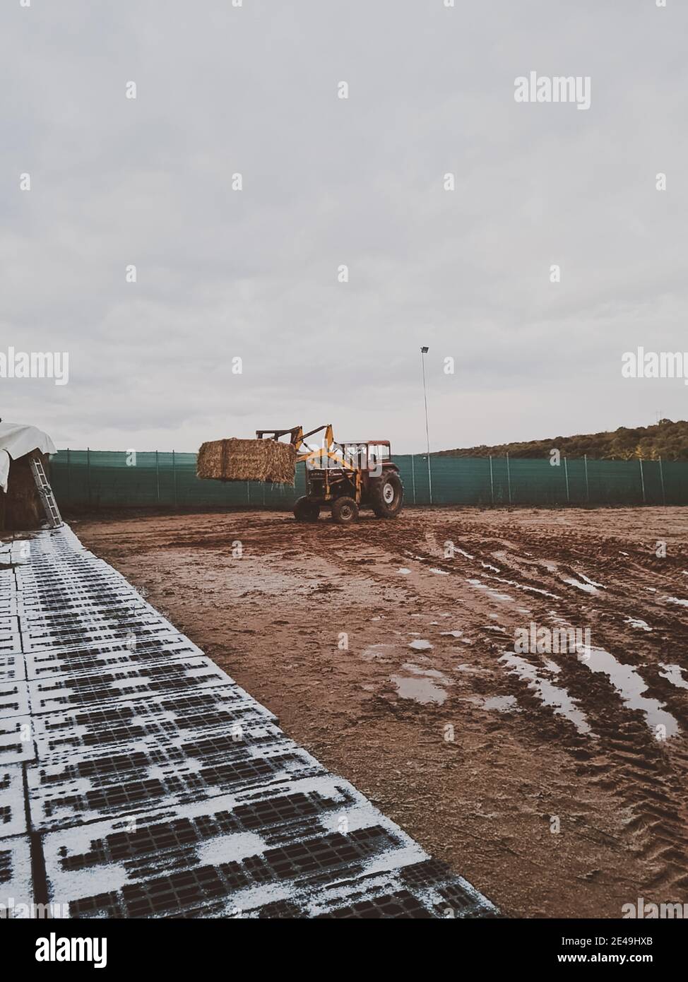tractor towing a straw bale on dirt track Stock Photo - Alamy
