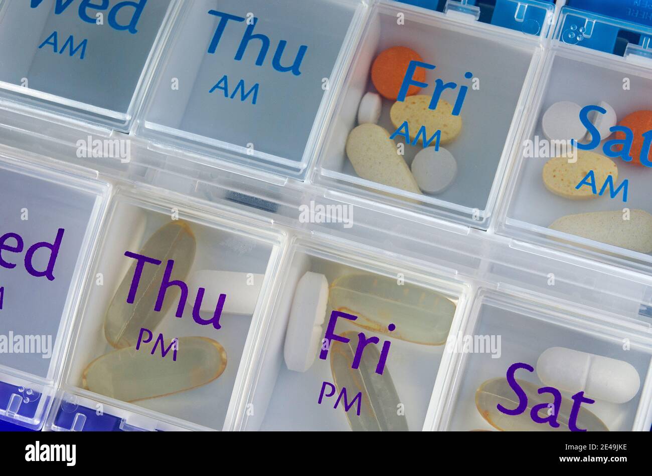 Closeup of a pillbox with medications, showing day of week and AM or PM ...