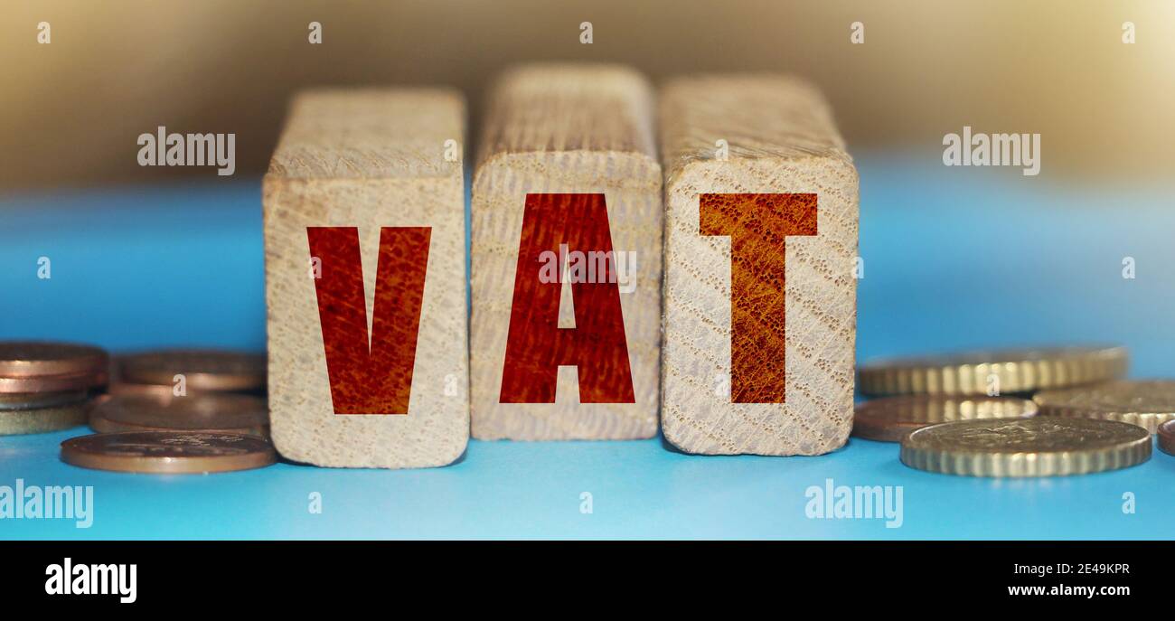 VAT abbreviation on Wooden Cubic Blocks and Many Coins. Taxes and fees ...