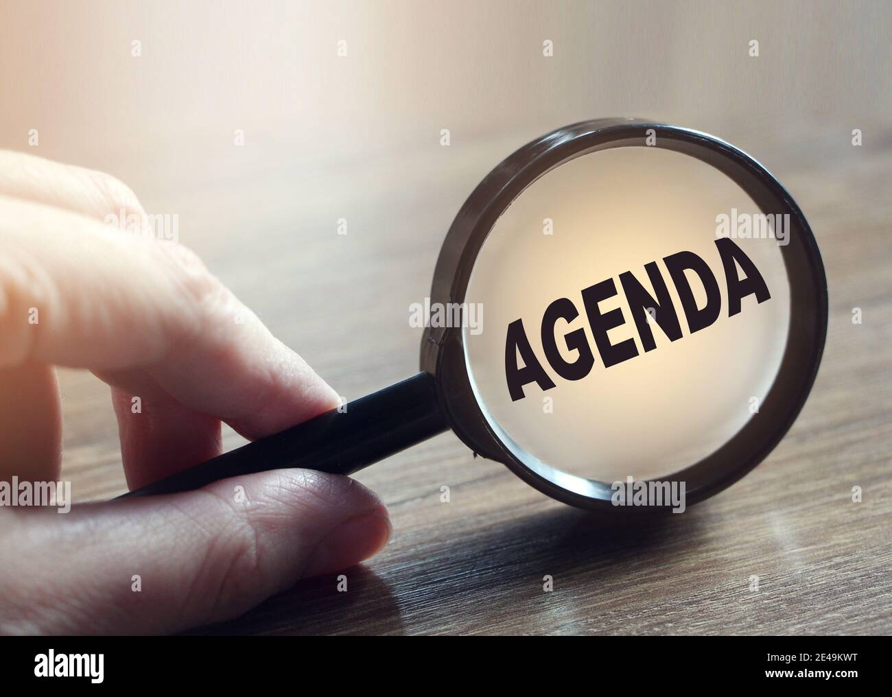 Hand Showing agenda Word Through Magnifying Glass. Business concept ...