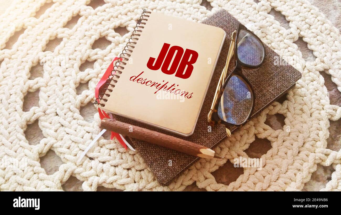 Job Description text on cover of the book, glasses and pen. Business ...