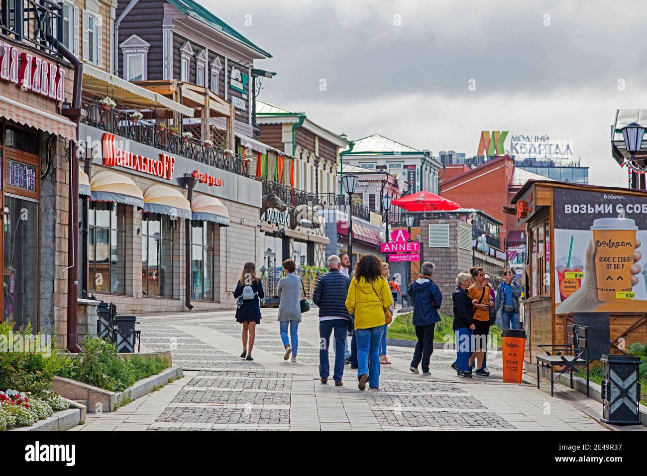 Shoppers in shopping street with shops and restaurants in the city ...