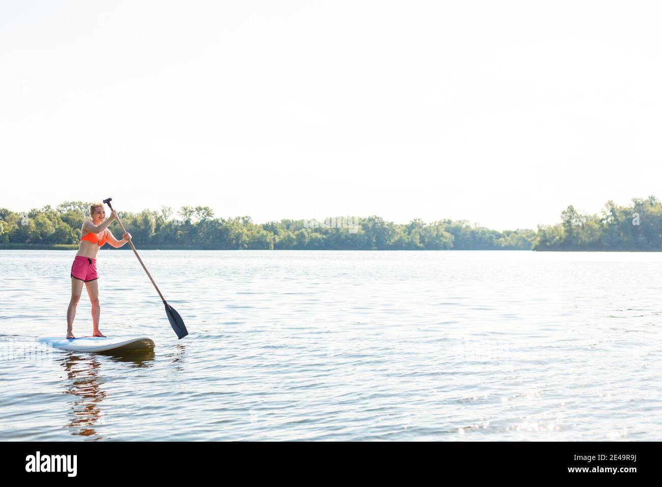 Action Shot of Young Woman on Paddle Board Stock Photo - Alamy