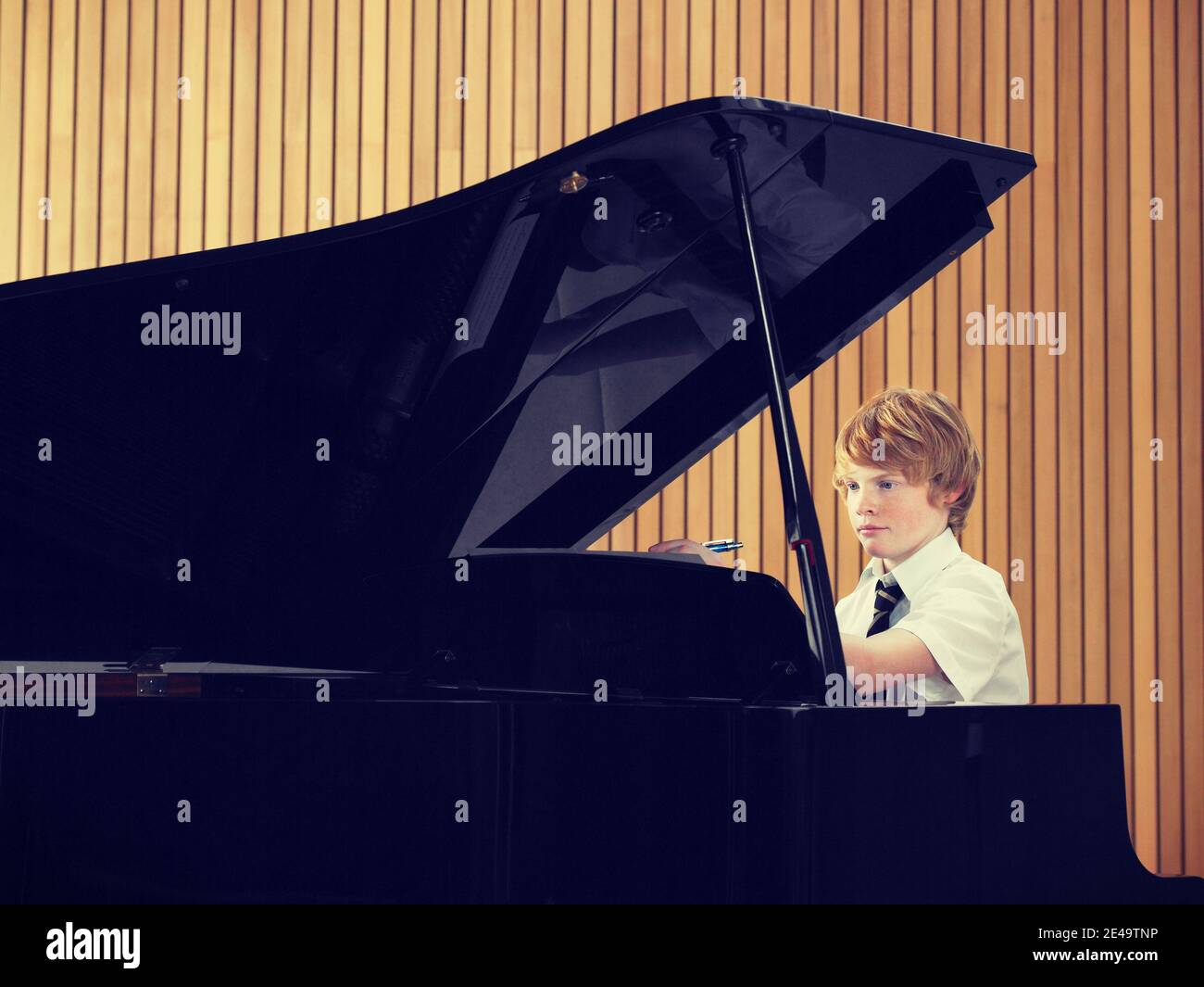 Teenage boy playing piano in music class Stock Photo - Alamy