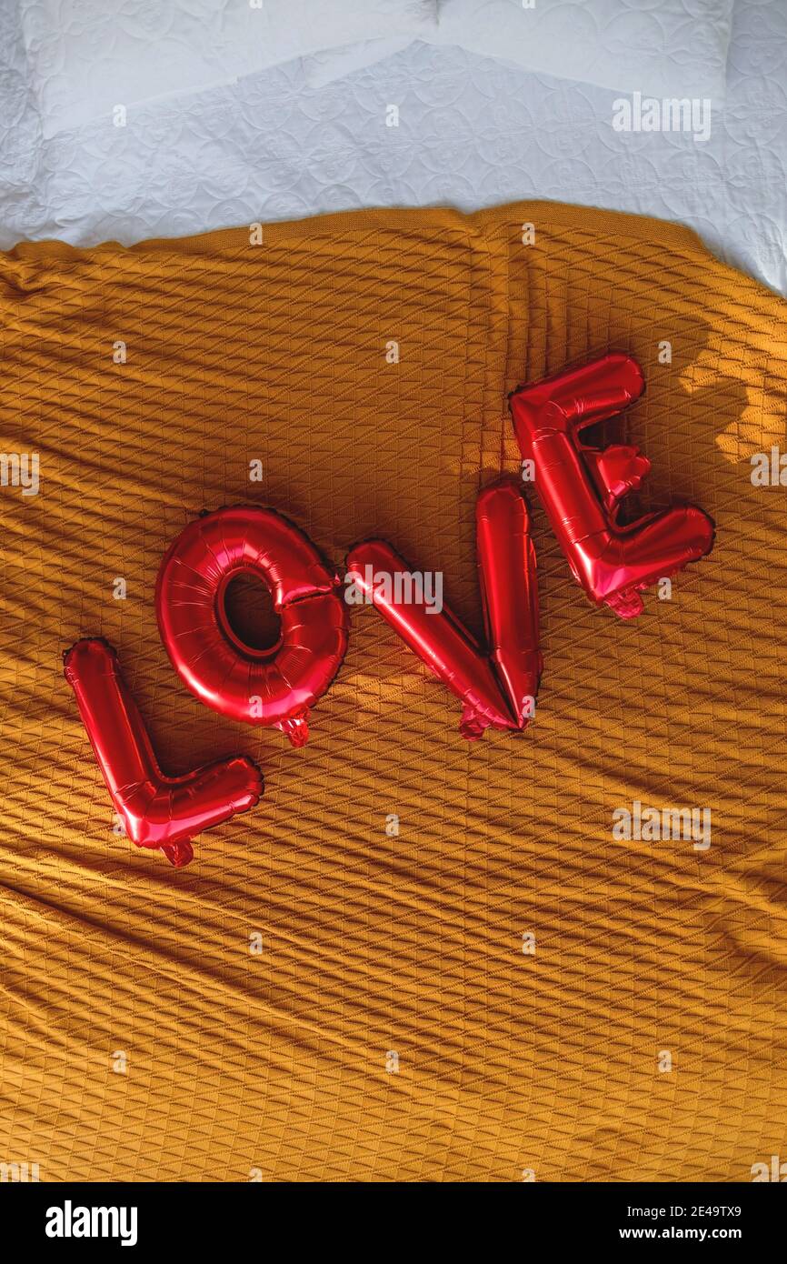 Red balloons in the shape of the lettering love on the bed Stock Photo ...