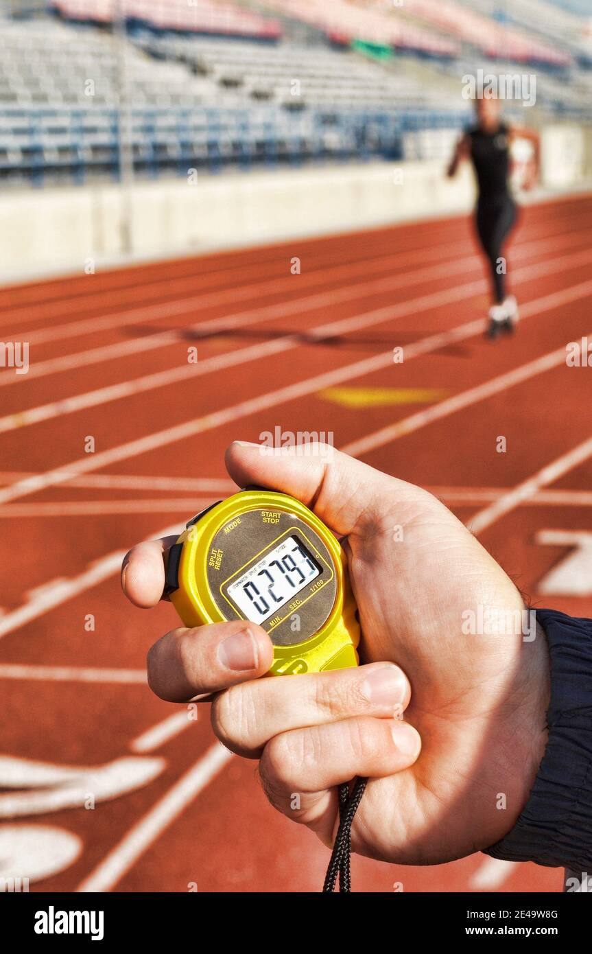 Coach holding Stopwatch Timing Runner Stock Photo - Alamy