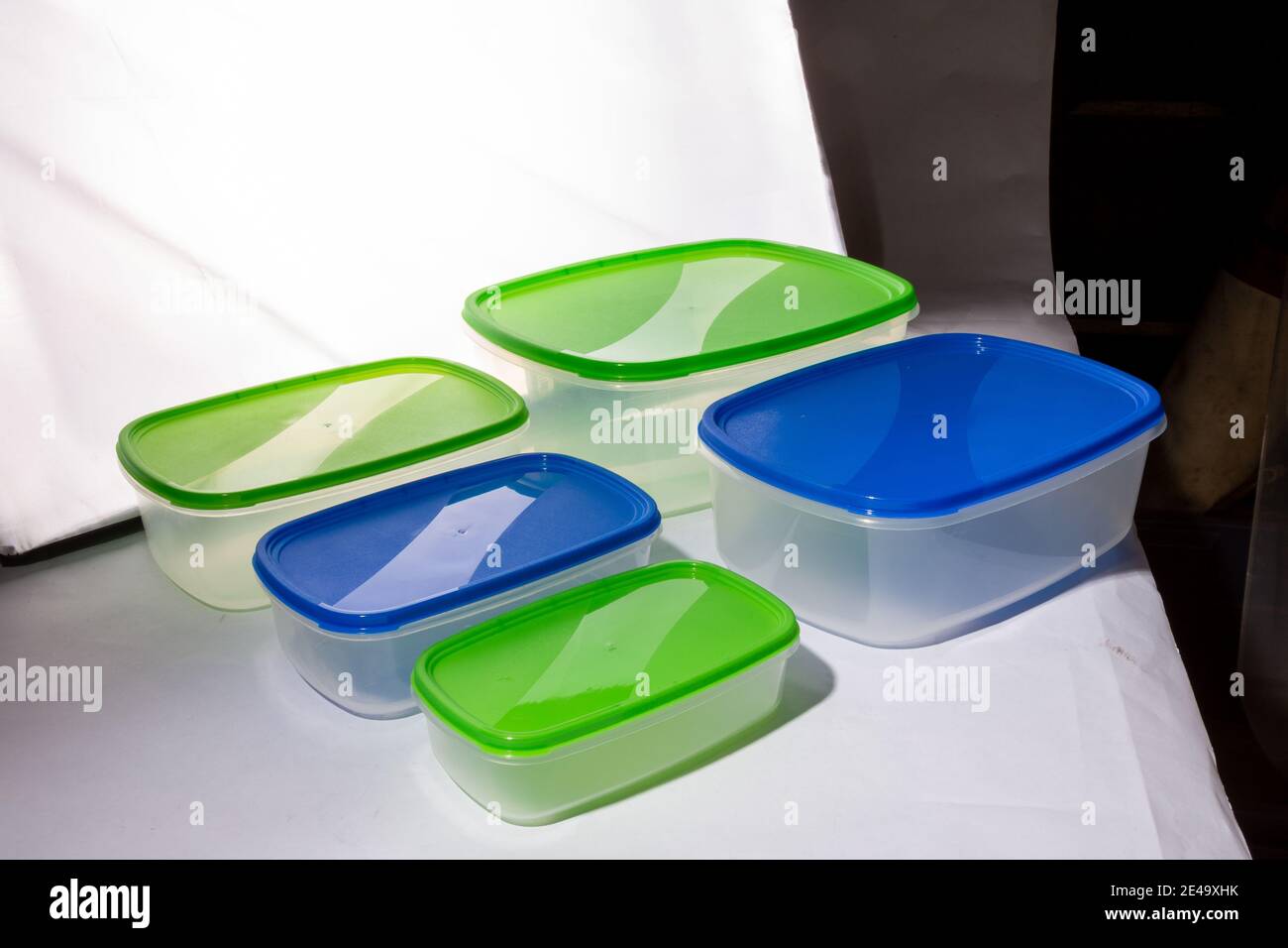 Set of plastic food containers of various volume with colored lids and ...