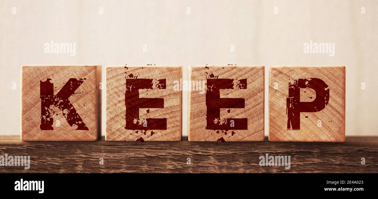 KEEP word on wooden cubes on a wooden background. Keeping things ...