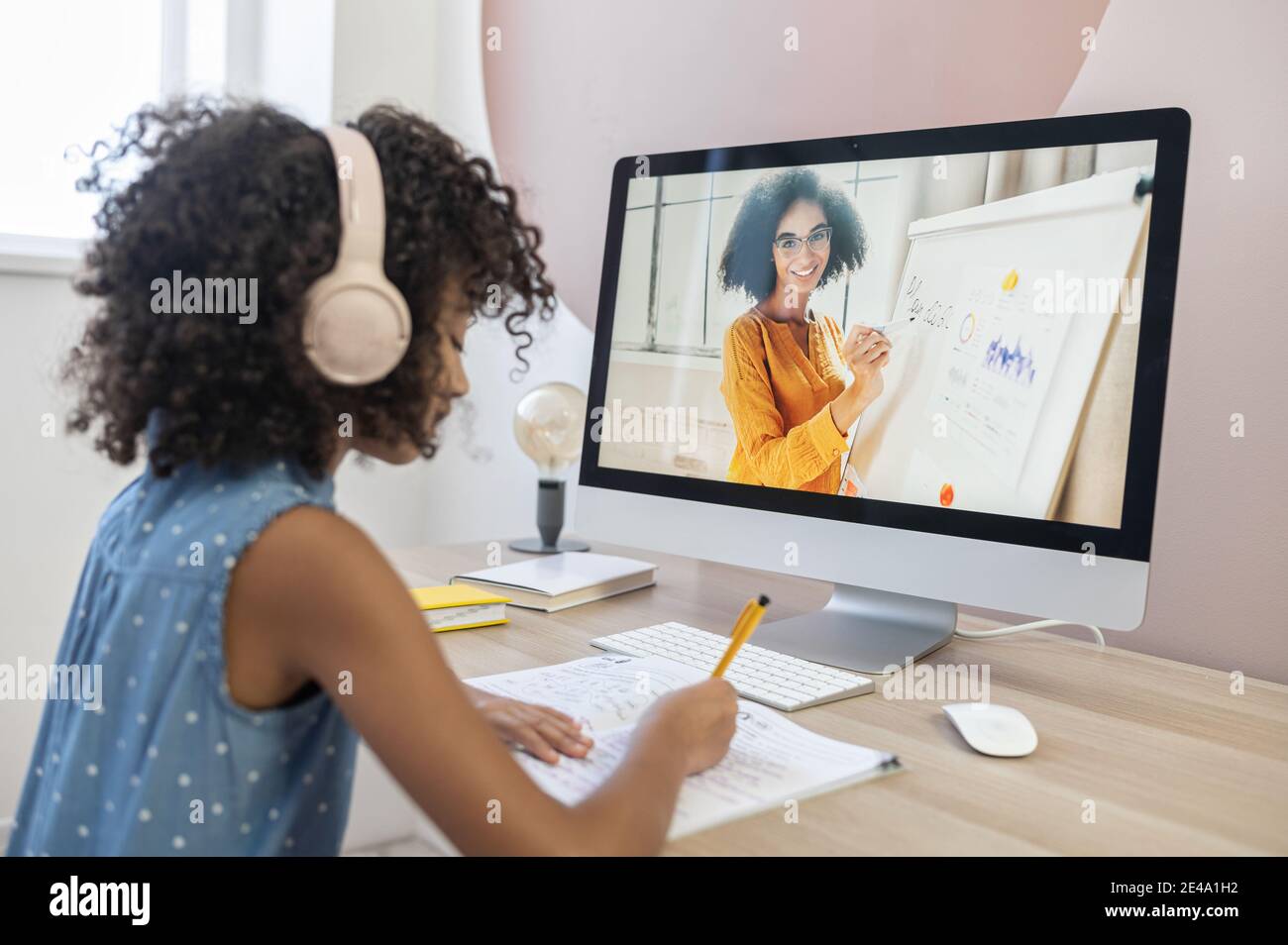 Homeschooling and technology concept. Cute clever schoolgirl fills ...