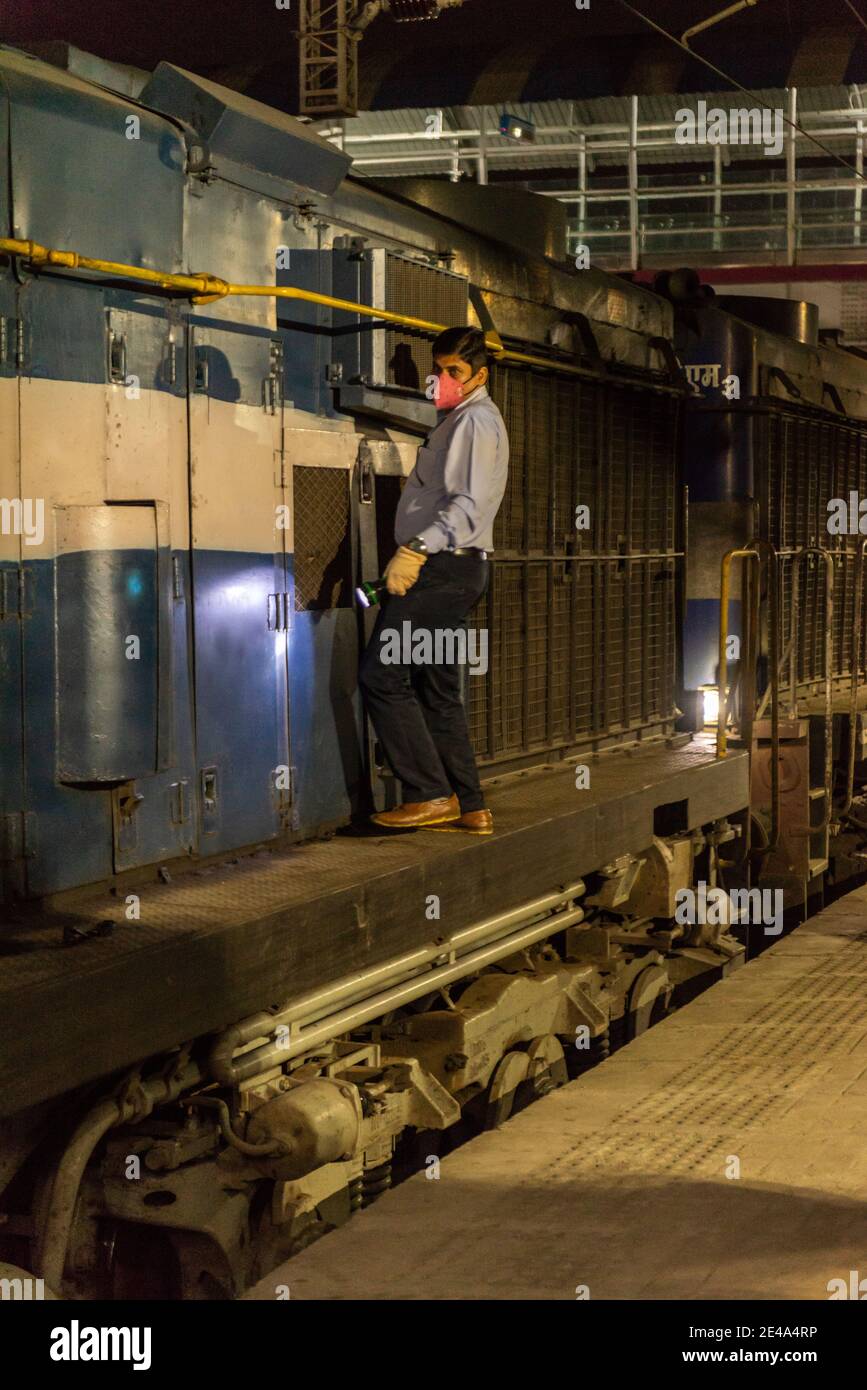 Loco pilot of WDM-3A class locomotive inspecting the engine with torch ...
