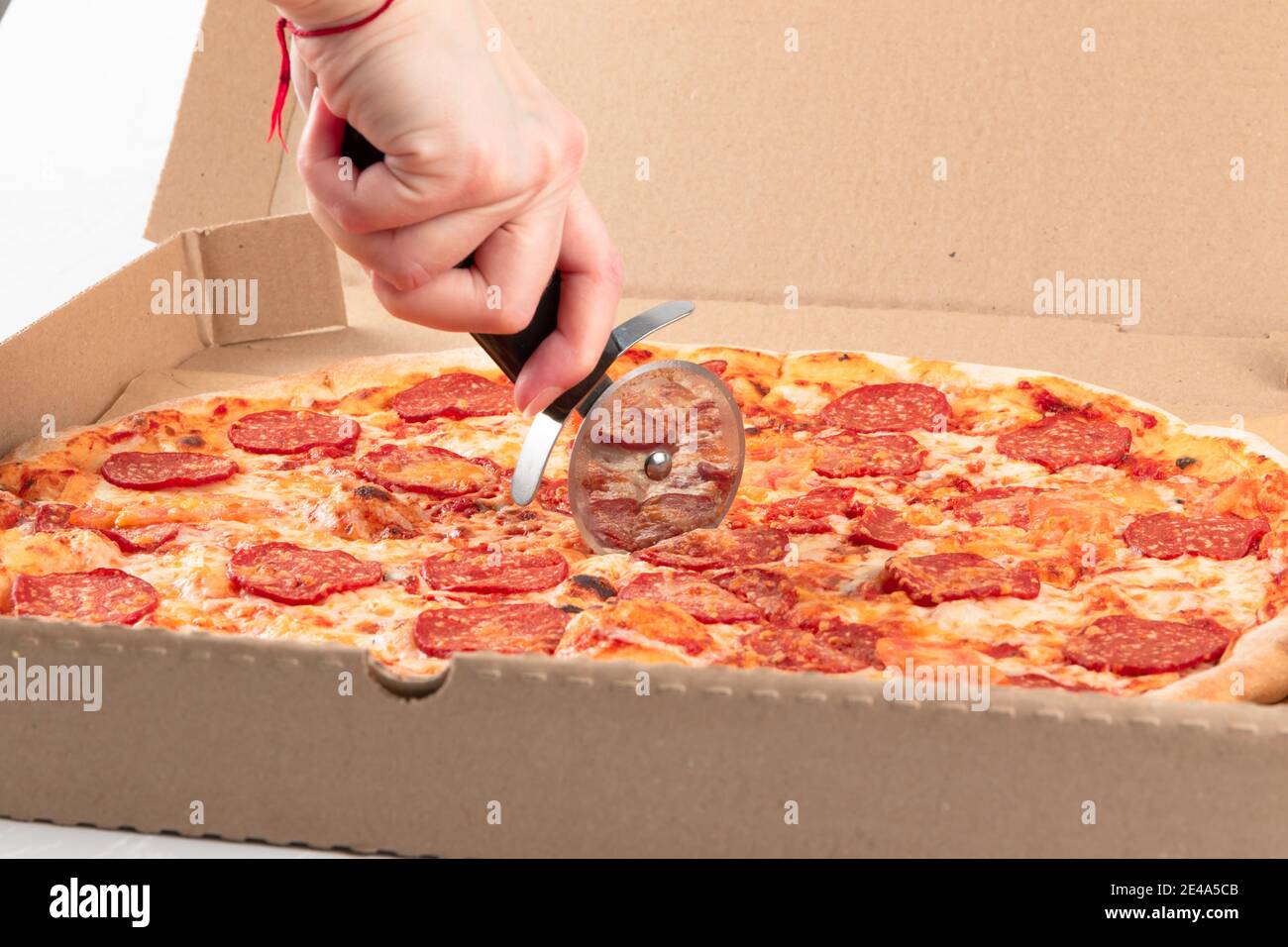 female hand cuts fresh aromatic hot Italian mozzarella pizza. close-up ...