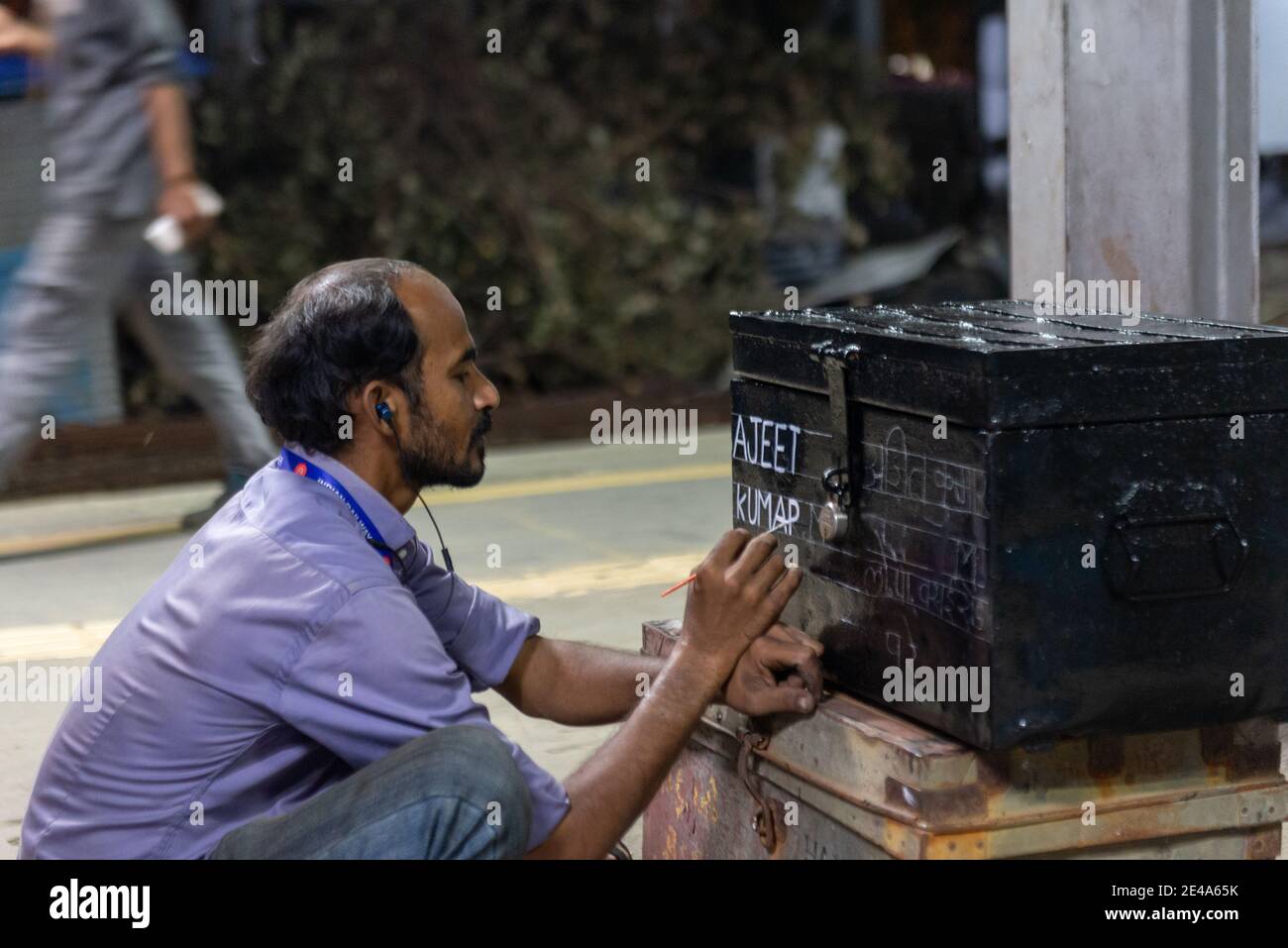 Railway station staff writing name of newly joined loco pilot on a line ...