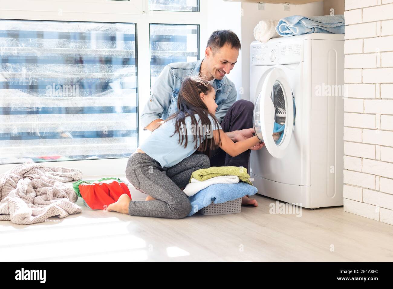 Happy family man father householder and child daughter in laundry with ...