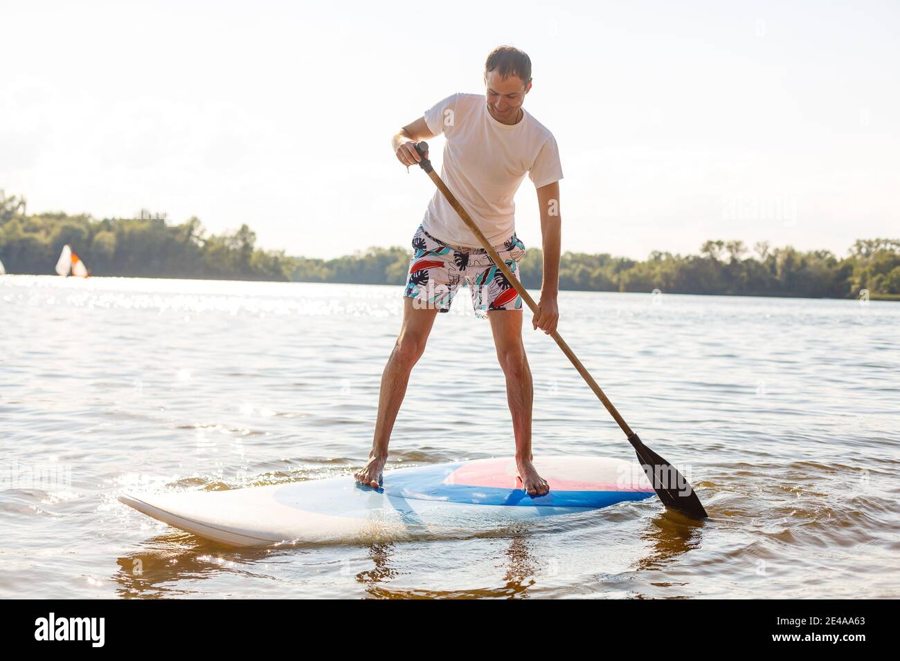 Silhouette of stand up paddle boarder paddling at sunset Stock Photo ...