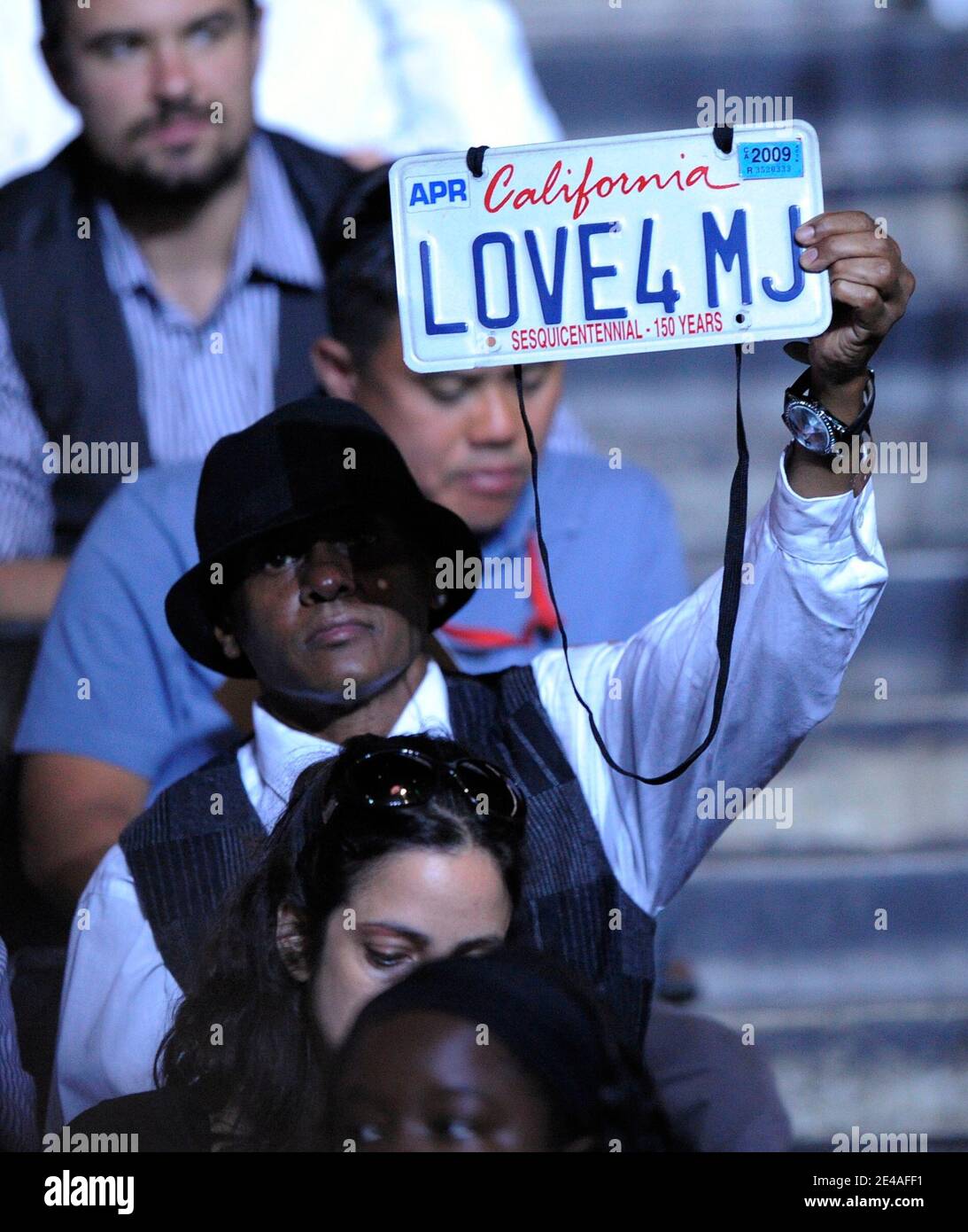 A fan holds up a license plate before the memorial service for Michael ...