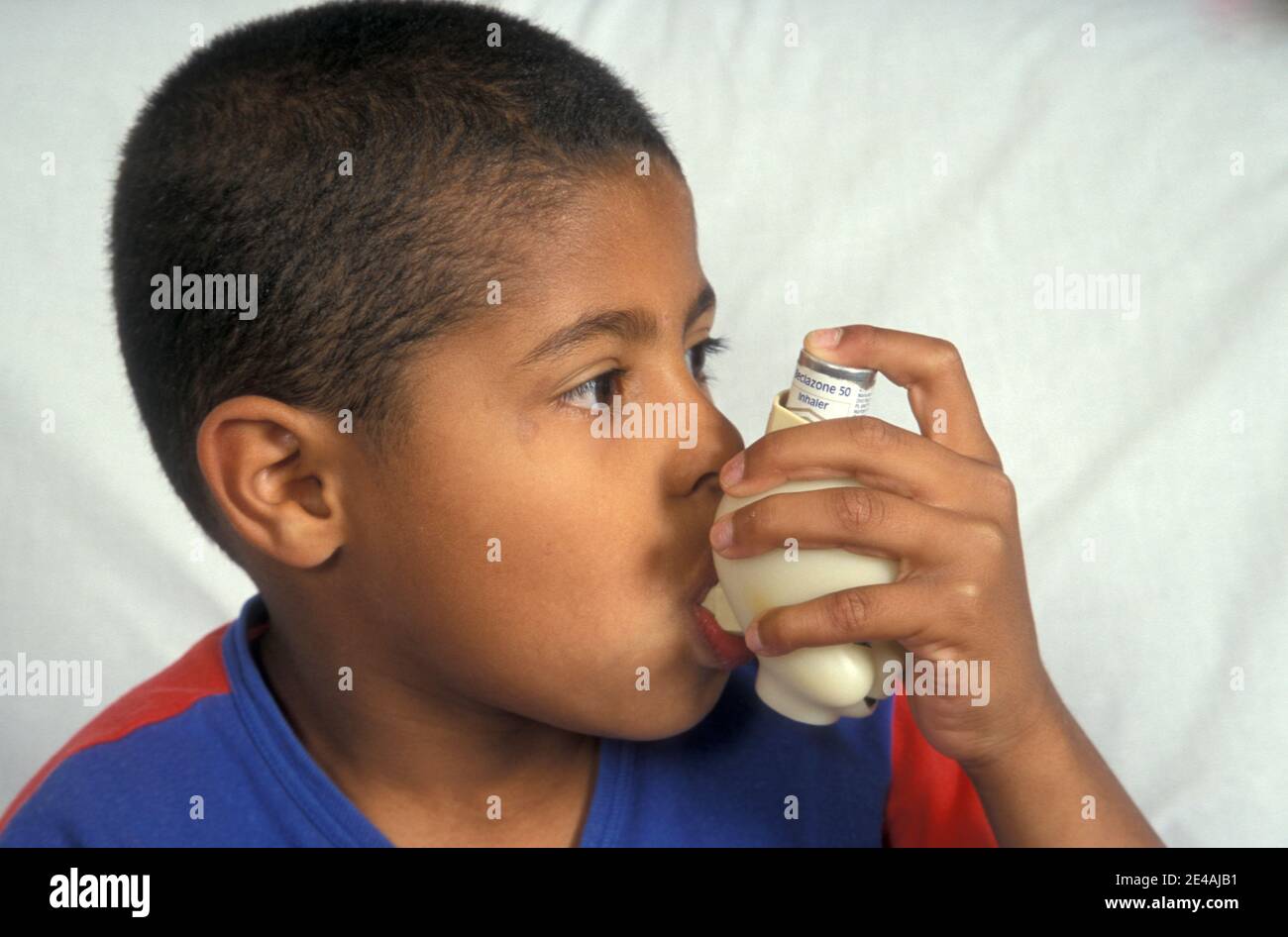 young black boy administering beclazone through inhaler Stock Photo - Alamy