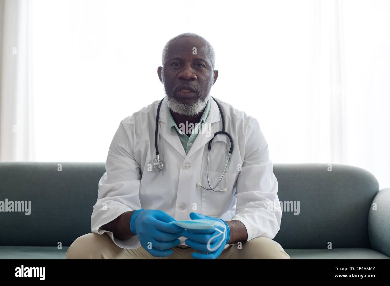 Portrait of senior african american male doctor giving patient ...