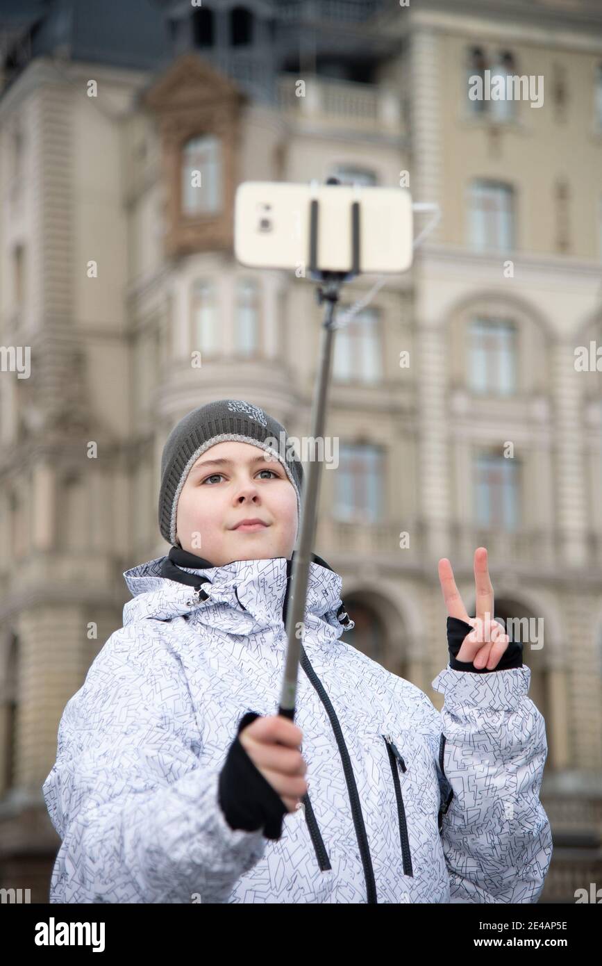boy does selfie on phone with self-stick against backdrop landmark ...