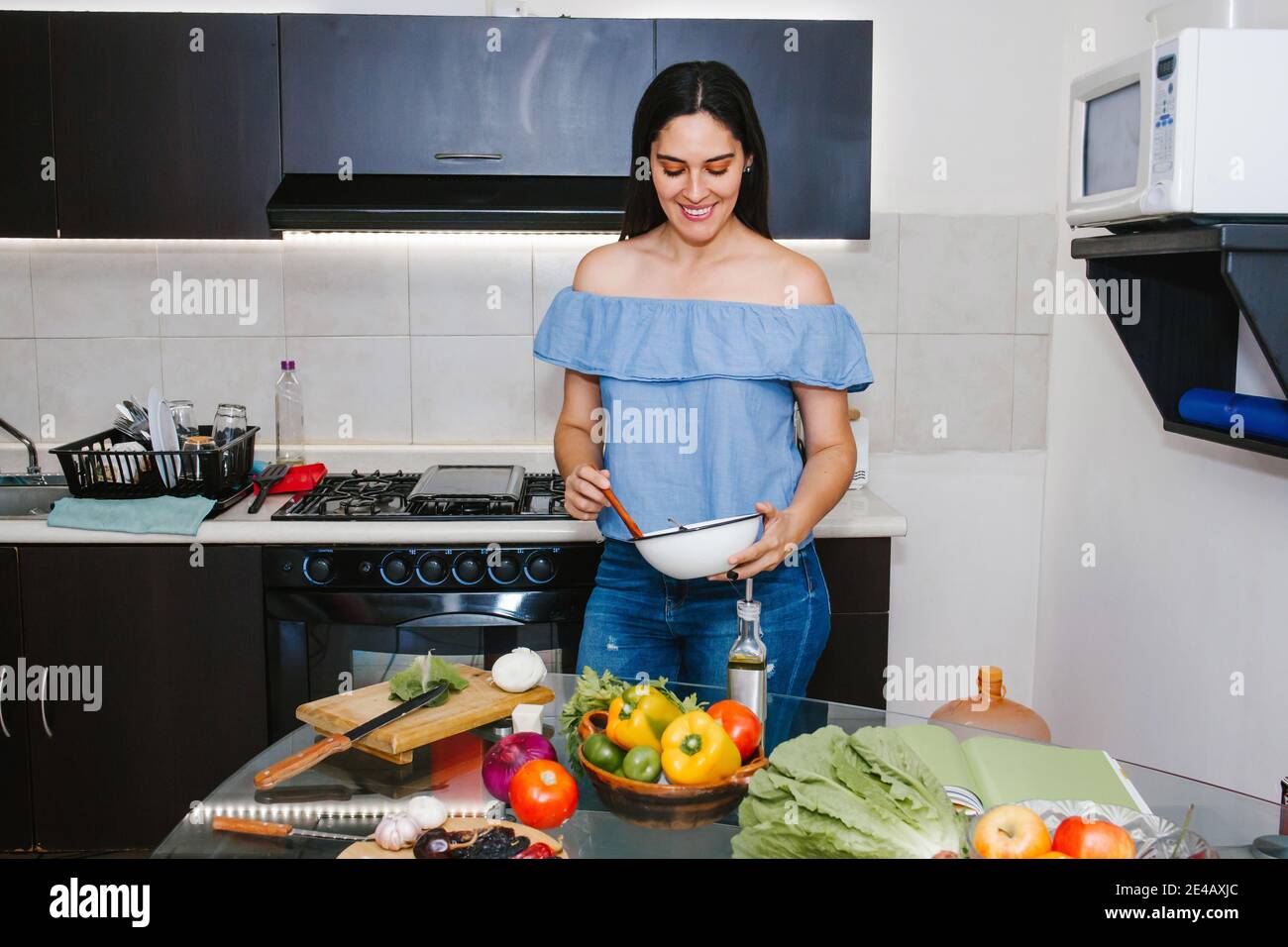 Latin woman cooking healthy food in a mexican kitchen in Mexico city ...