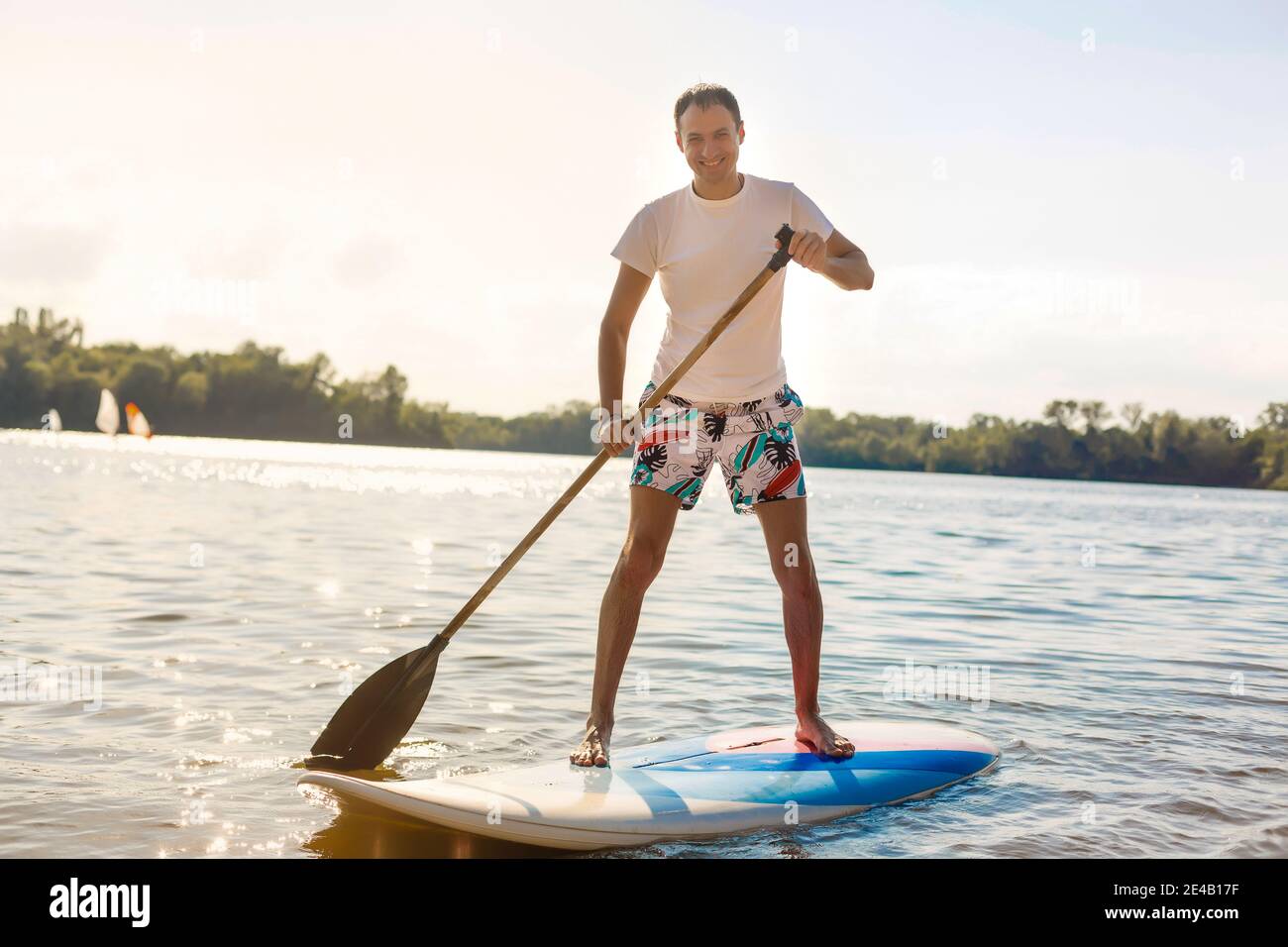 Silhouette of paddle boarder at sunset hi-res stock photography and ...