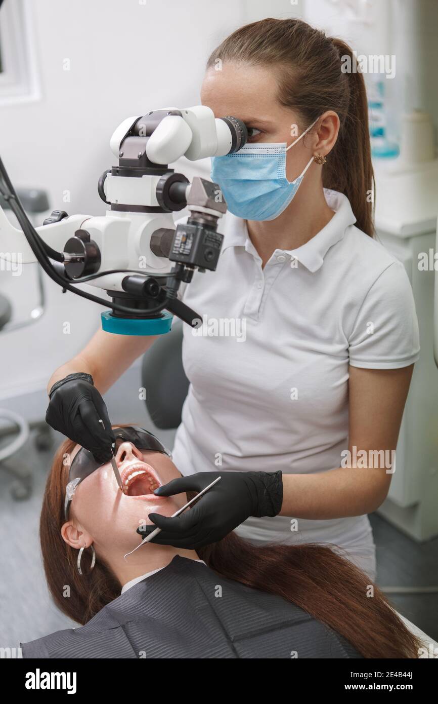 Vertical shot of a professional dentist using dental microscope ...