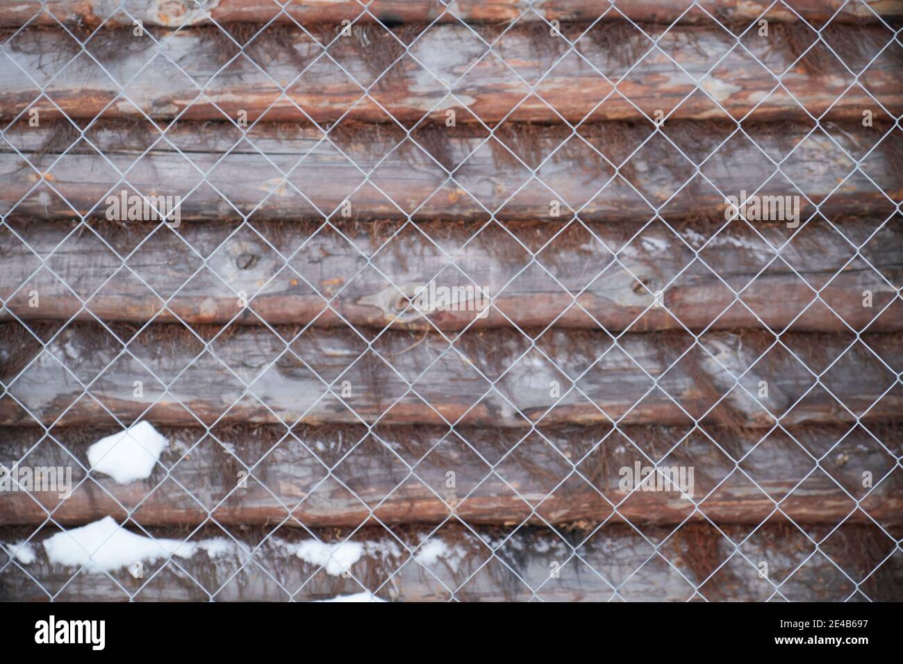 The fence background texture close up. metal mesh netting and logs ...