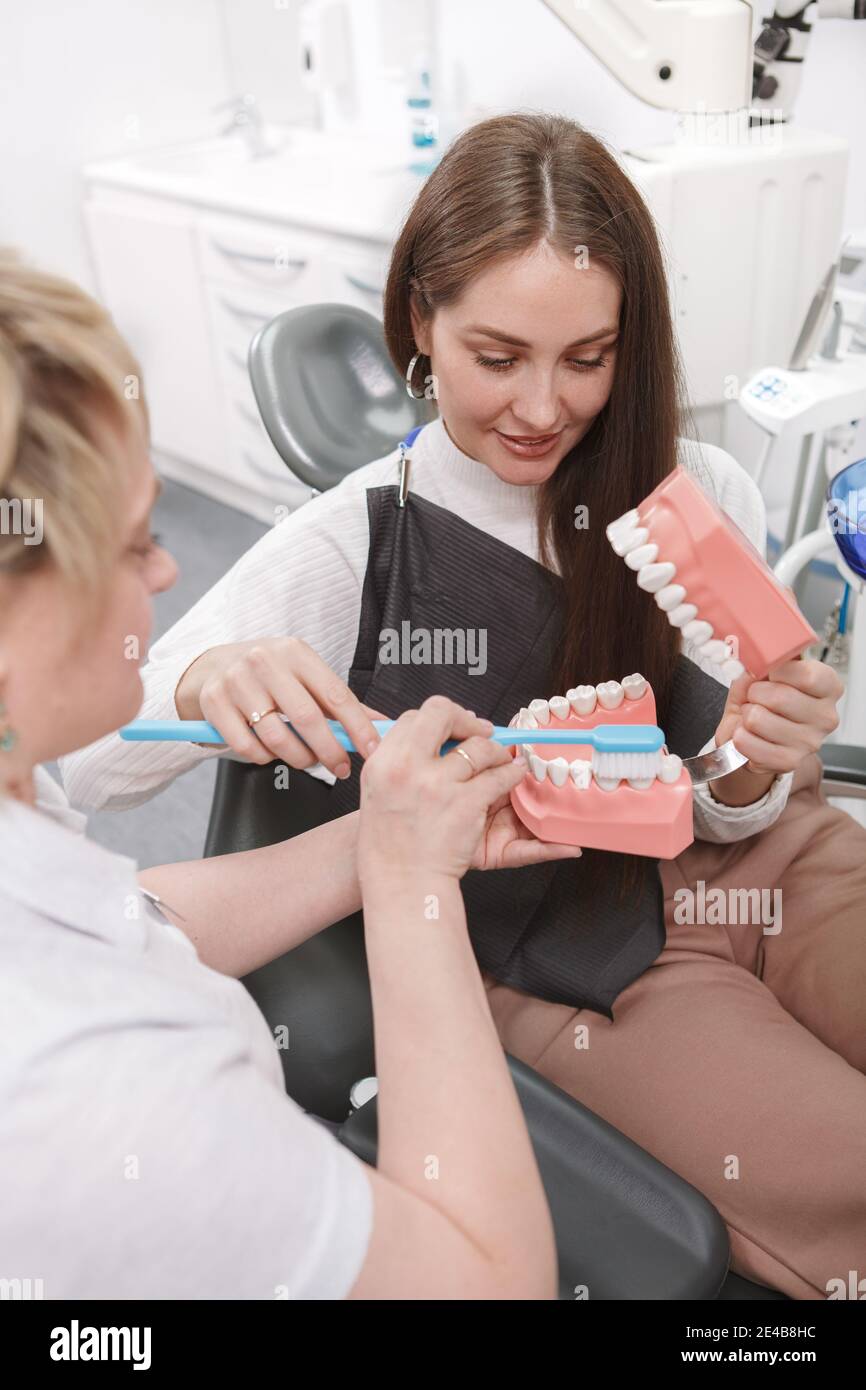 Vertical top view shot of a dentist showing how to brush teeth on ...