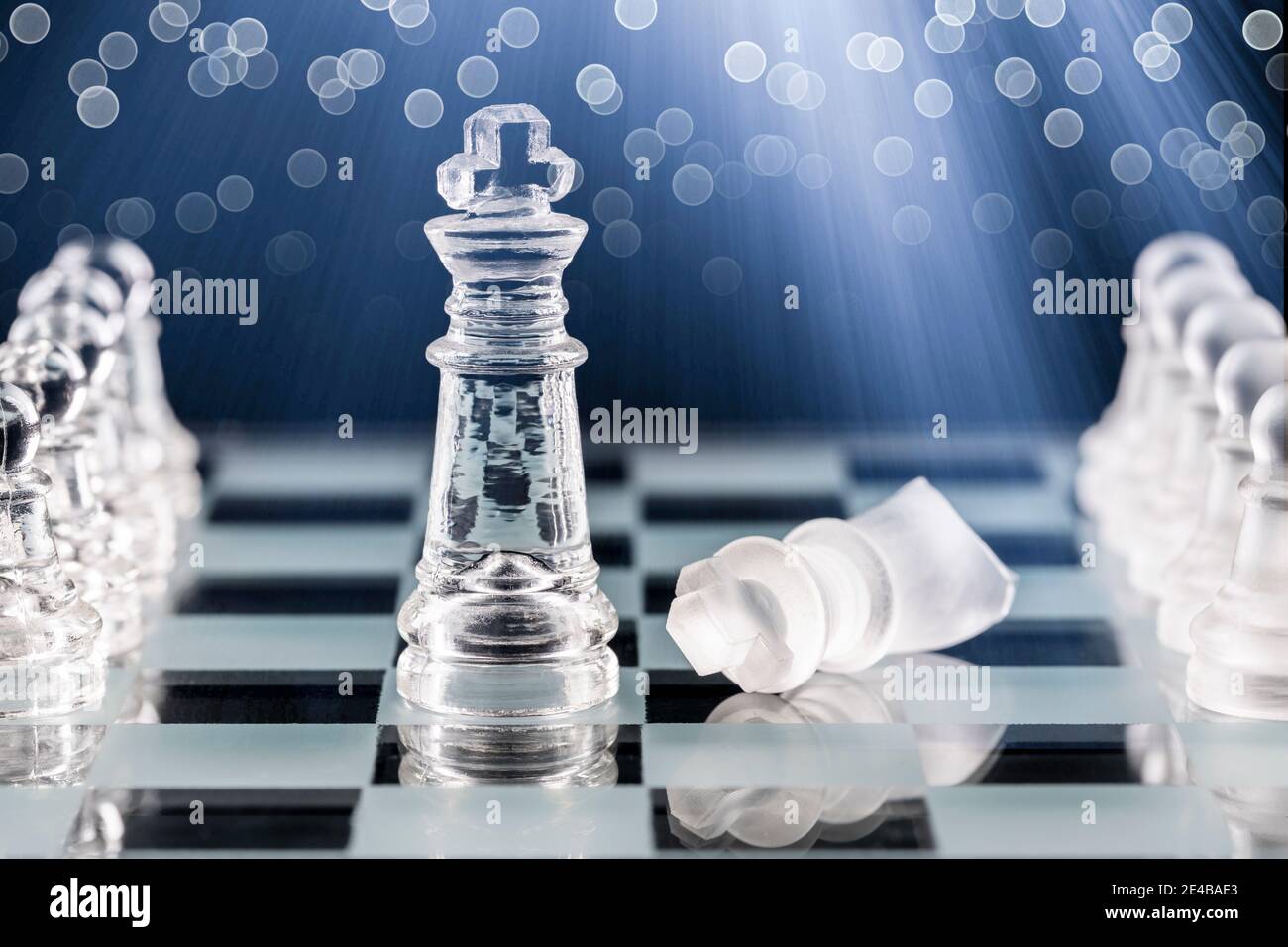 Glass chess pieces on a glass chessboard with reflection, on a blue ...