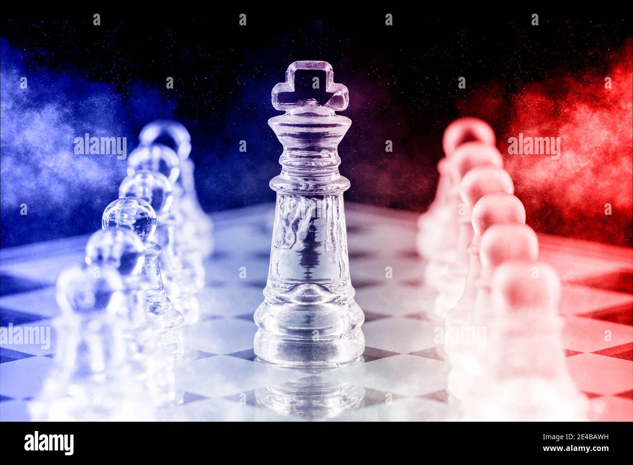 Glass chess pieces with blue and red light on a glass chessboard with ...