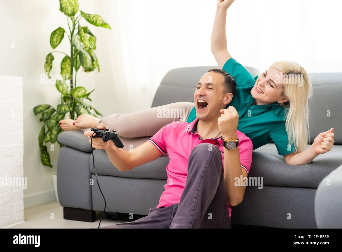 Man and woman playing video games with joystick at home Stock Photo - Alamy