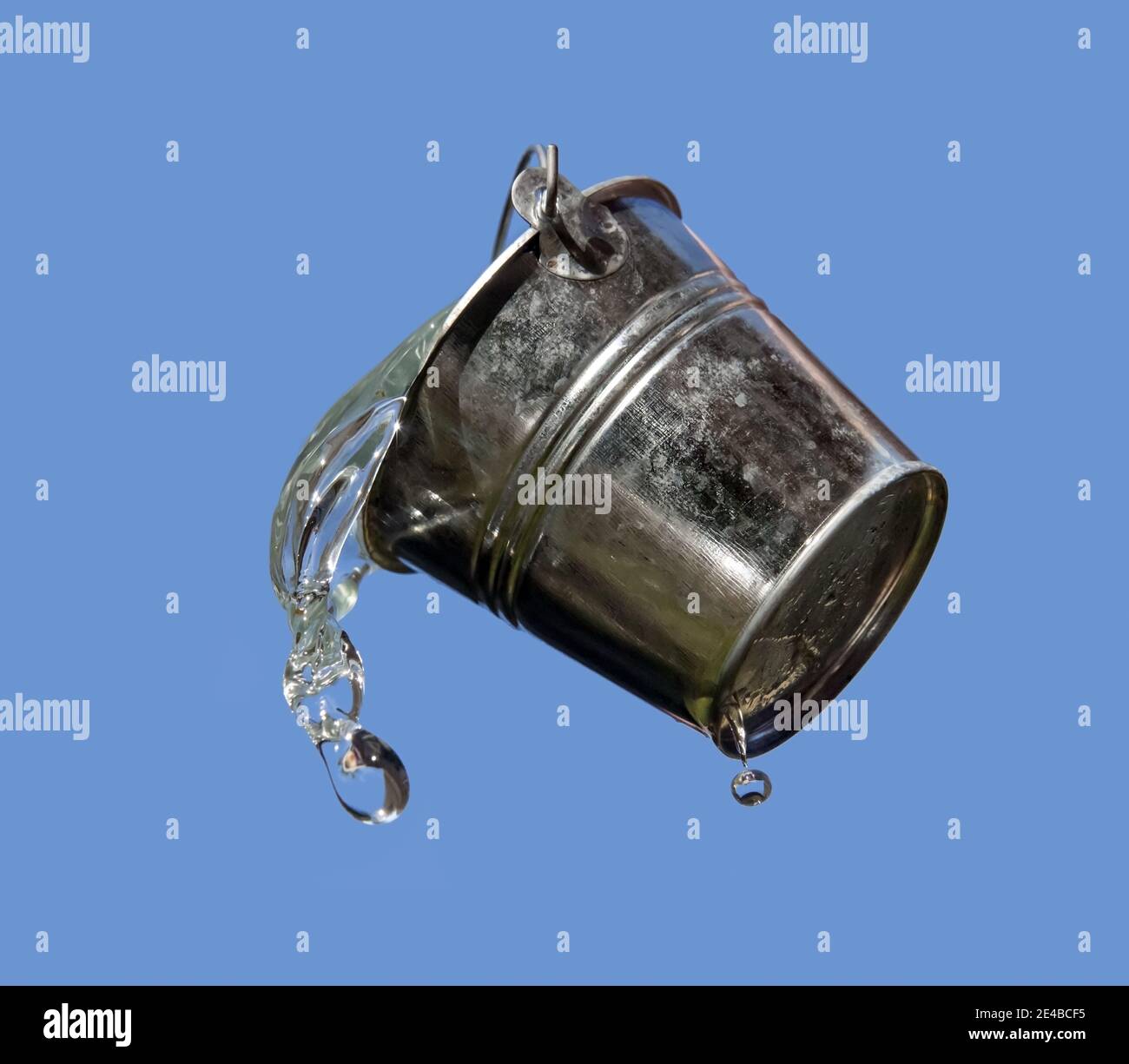 A falling buckets splashes water, on a background of blue sky Stock ...