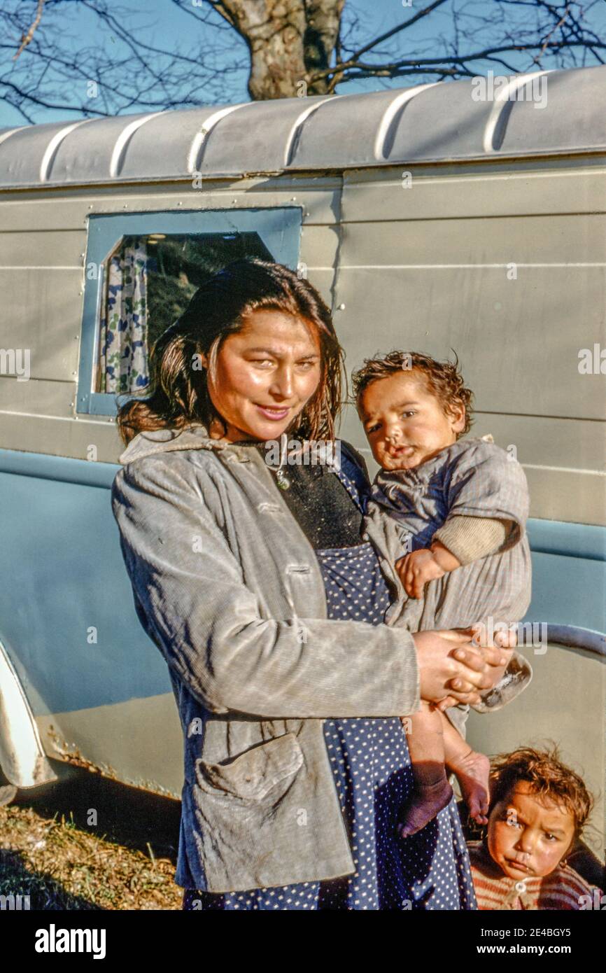 Gypsy woman with two young children standing next to camper, La Roque ...