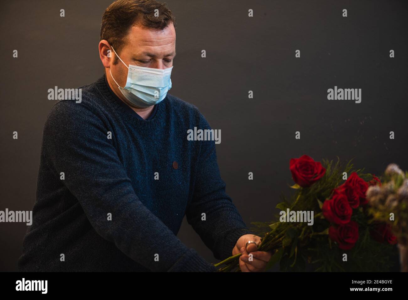 Caucasian florist selling bouquets of red and pink roses for valentine ...