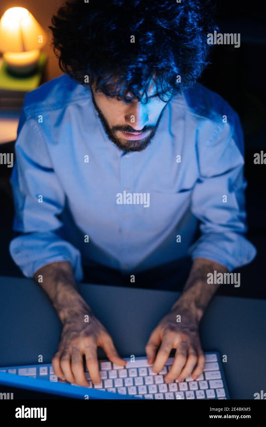 Top view of young man watching on monitor screen and working on ...