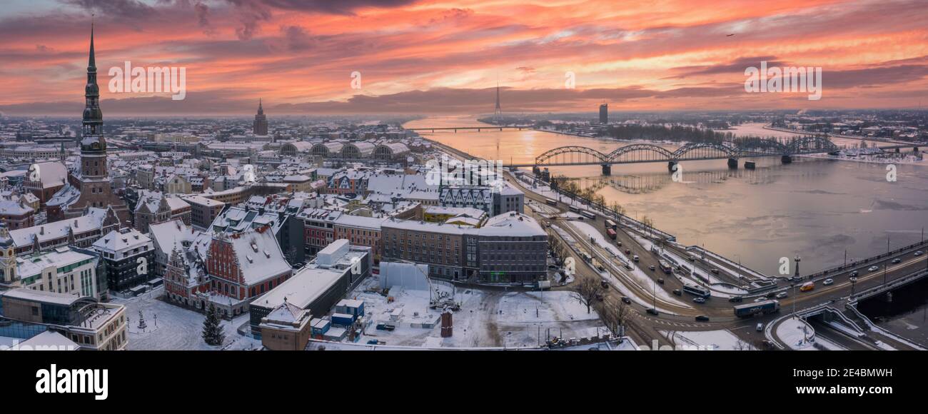 Panoramic shot of beautiful sunset over snow-covered Riga town with ...