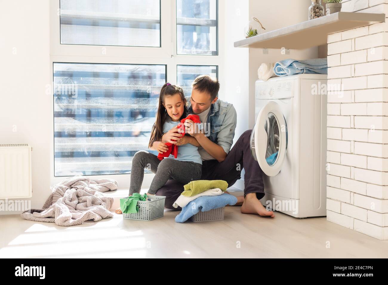 Happy Family loading clothes into washing machine in home Stock Photo ...