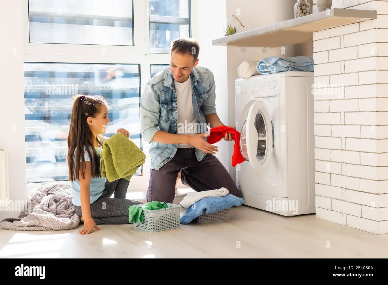 Happy Family loading clothes into washing machine in home Stock Photo ...