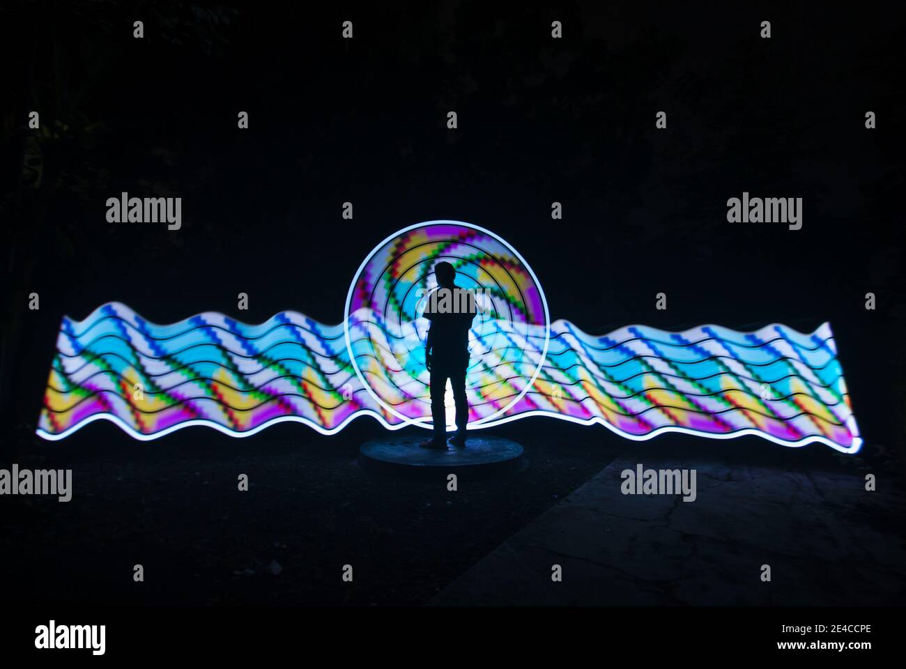 One person standing alone against beautiful color circle LED light ...