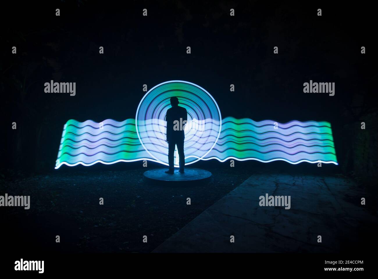 One person standing alone against beautiful color circle LED light ...