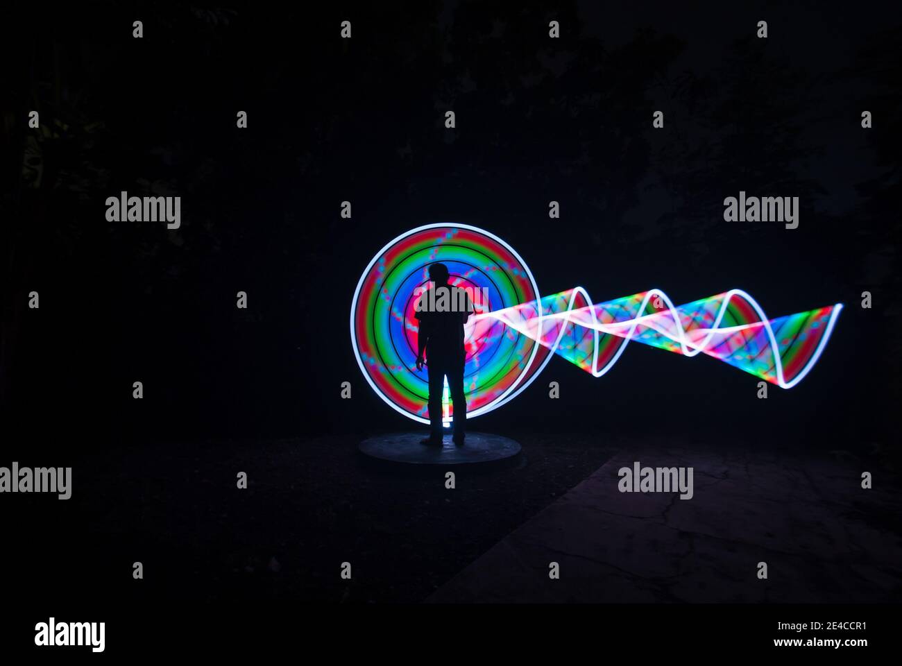 One person standing alone against beautiful color circle LED light ...