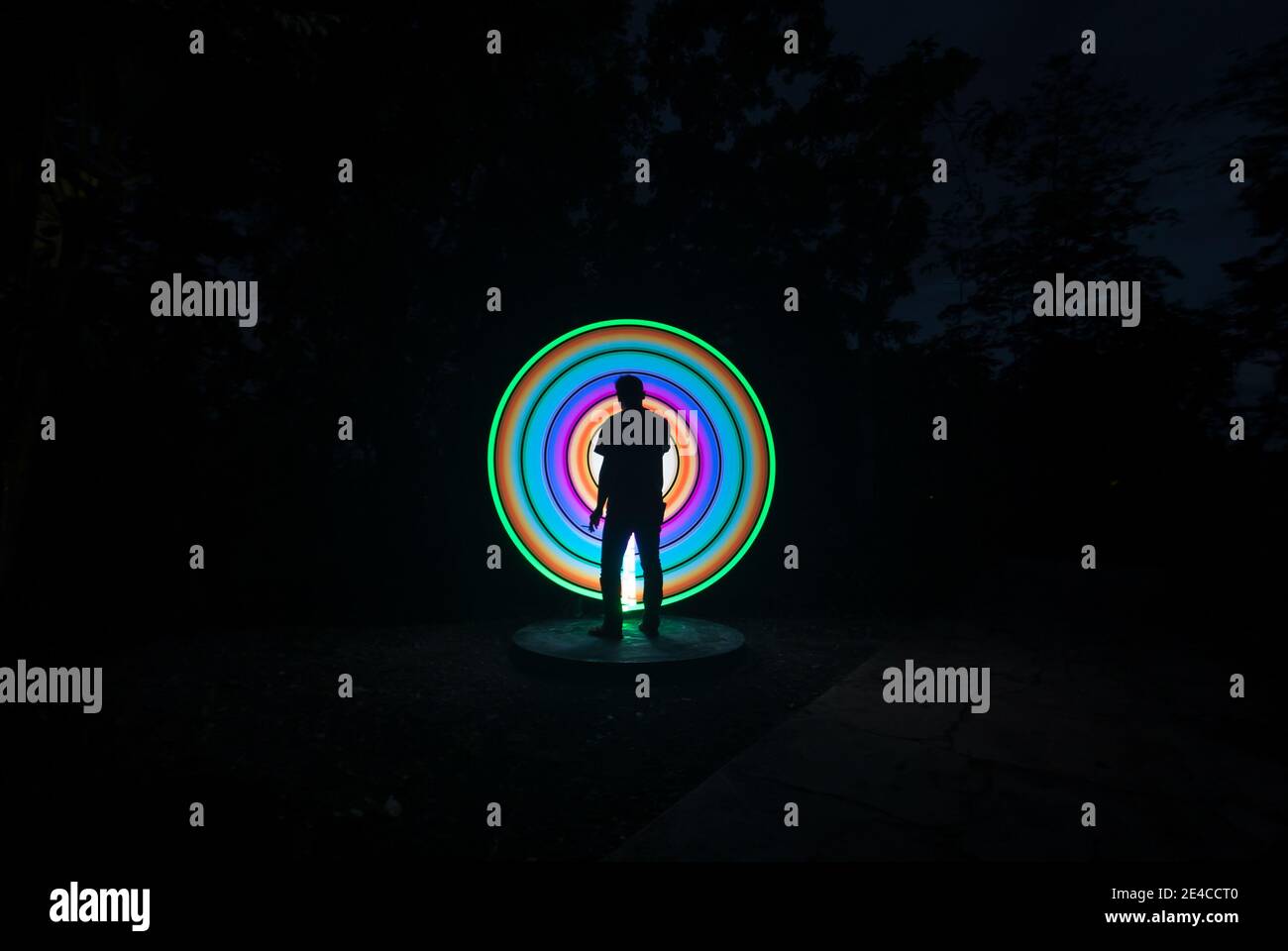 One person standing alone against beautiful color circle LED light ...