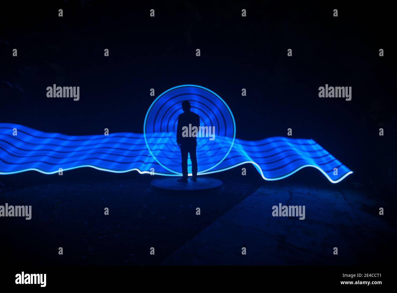 One person standing alone against beautiful color circle LED light ...