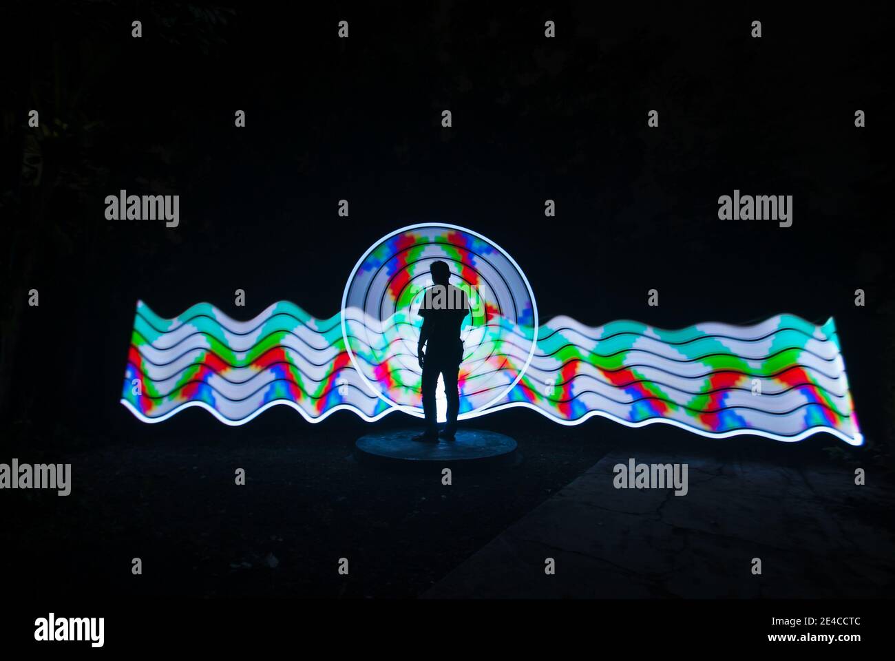 One person standing alone against beautiful color circle LED light ...