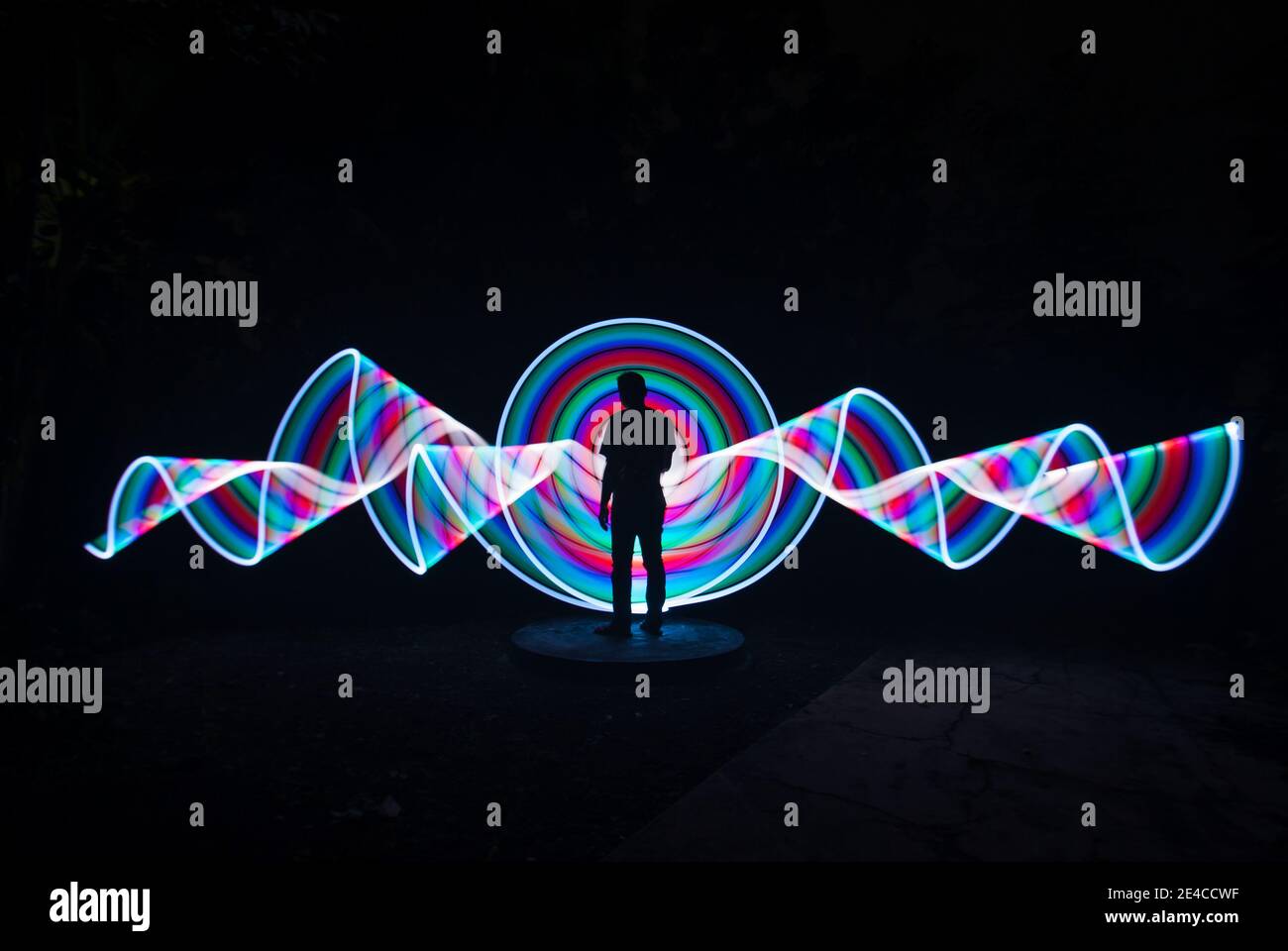 One person standing alone against beautiful color circle LED light ...