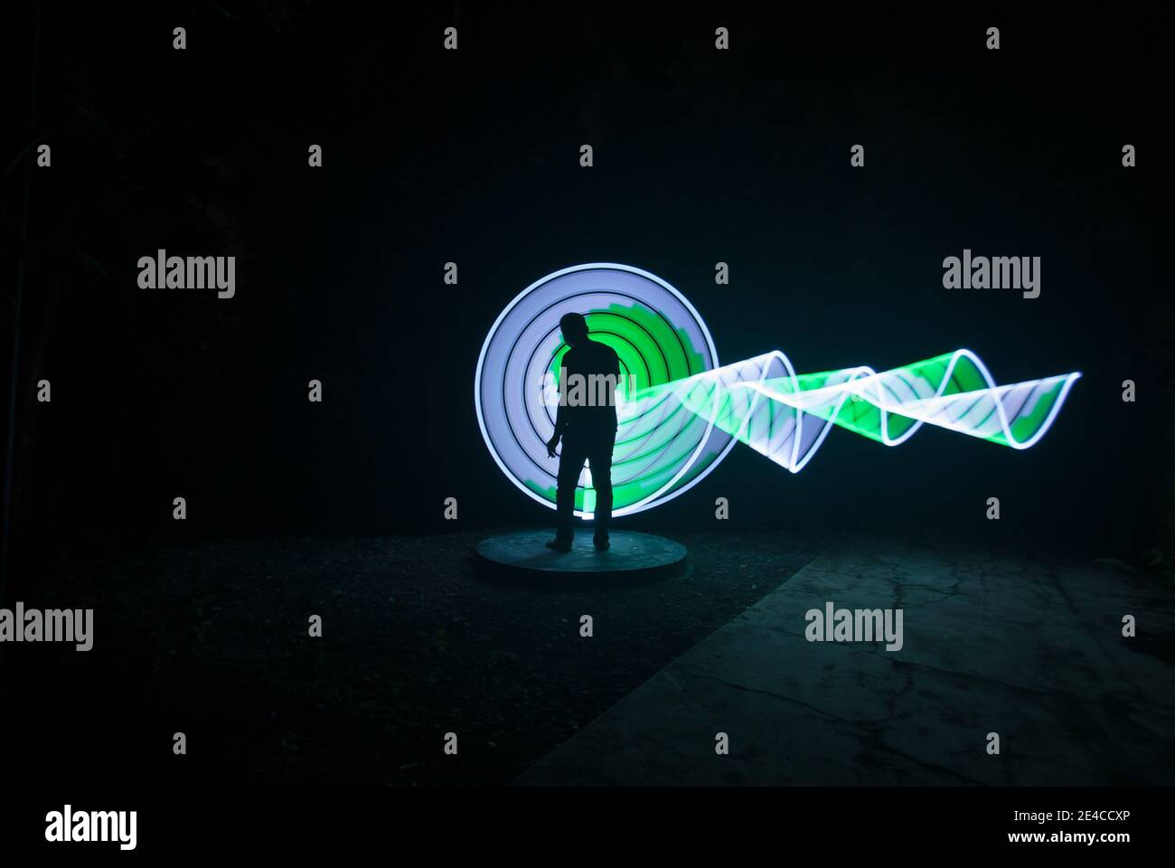 One person standing alone against beautiful color circle LED light ...