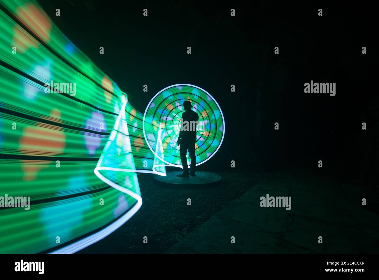 One person standing alone against beautiful color circle LED light ...