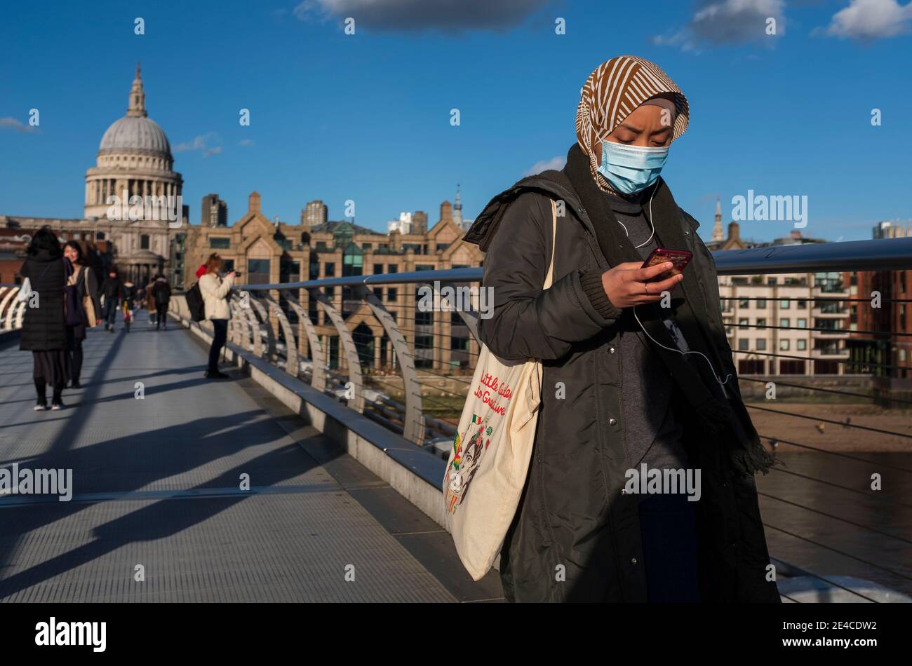 A lady wearing a face mask walks along the millennium pedestrian bridge ...